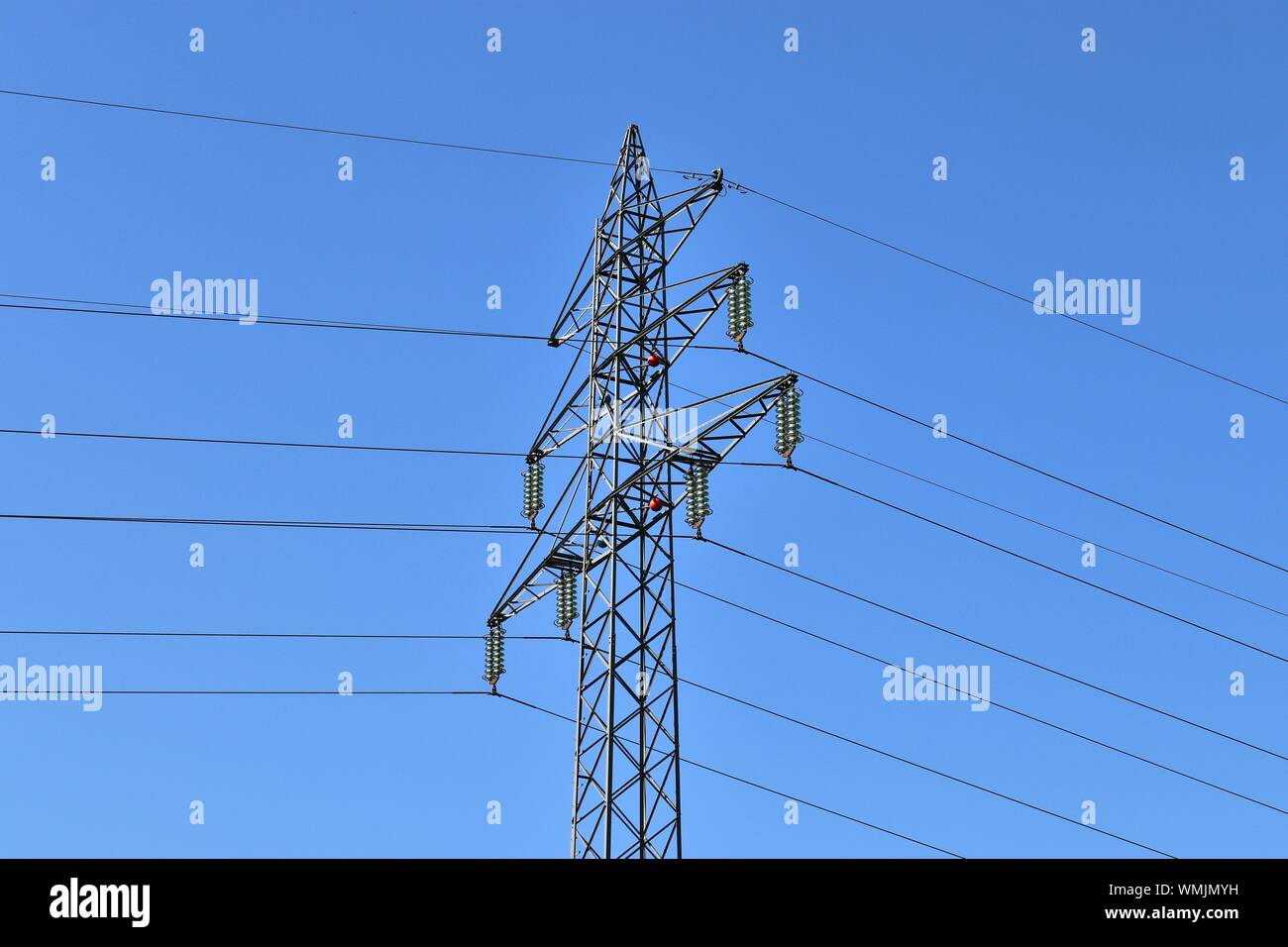 Close up view on a steel power pylon with high voltage power lines ...