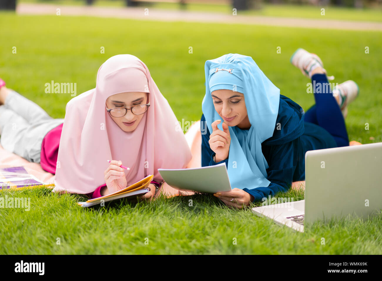 Two muslim students sitting on grass and preparing to exam Stock Photo ...