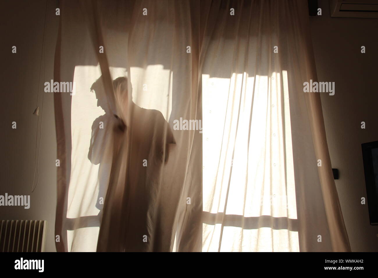 Man Behind Curtain At Home Stock Photo - Alamy