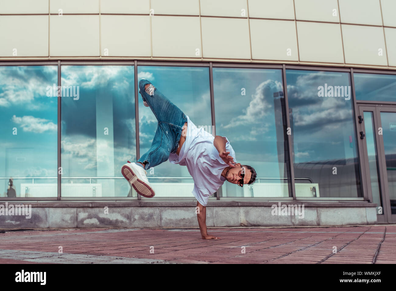strong sporty man dancing break dance, stands one arm red-haired, young ...