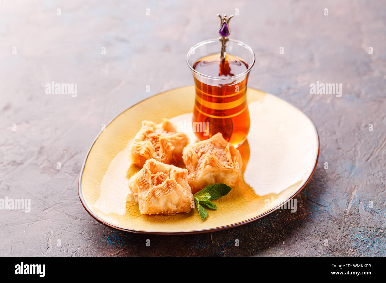 Middle Eastern or Arabic tea with mint in a traditional glass cup and ...
