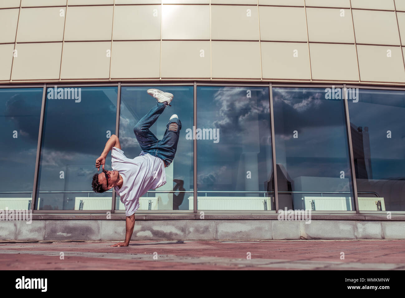 strong sporty man dancing break dance, stands one arm red-haired, young ...