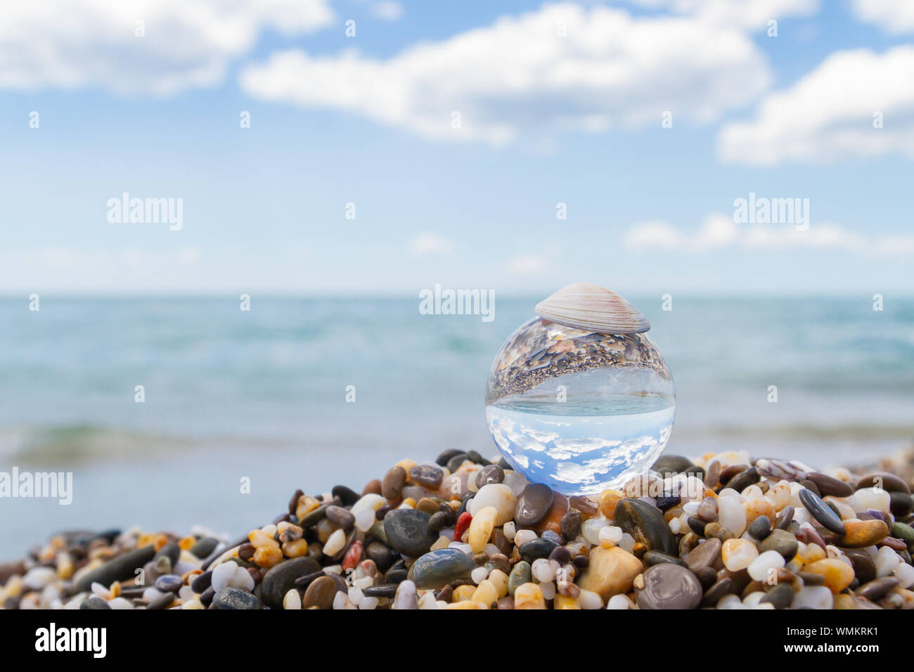 Glass round ball on the beach reflects the sea in summer Stock Photo ...