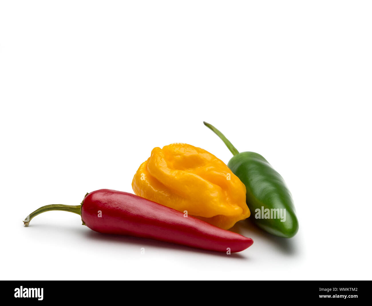 Three peppers of different shape and color isolated on white background ...