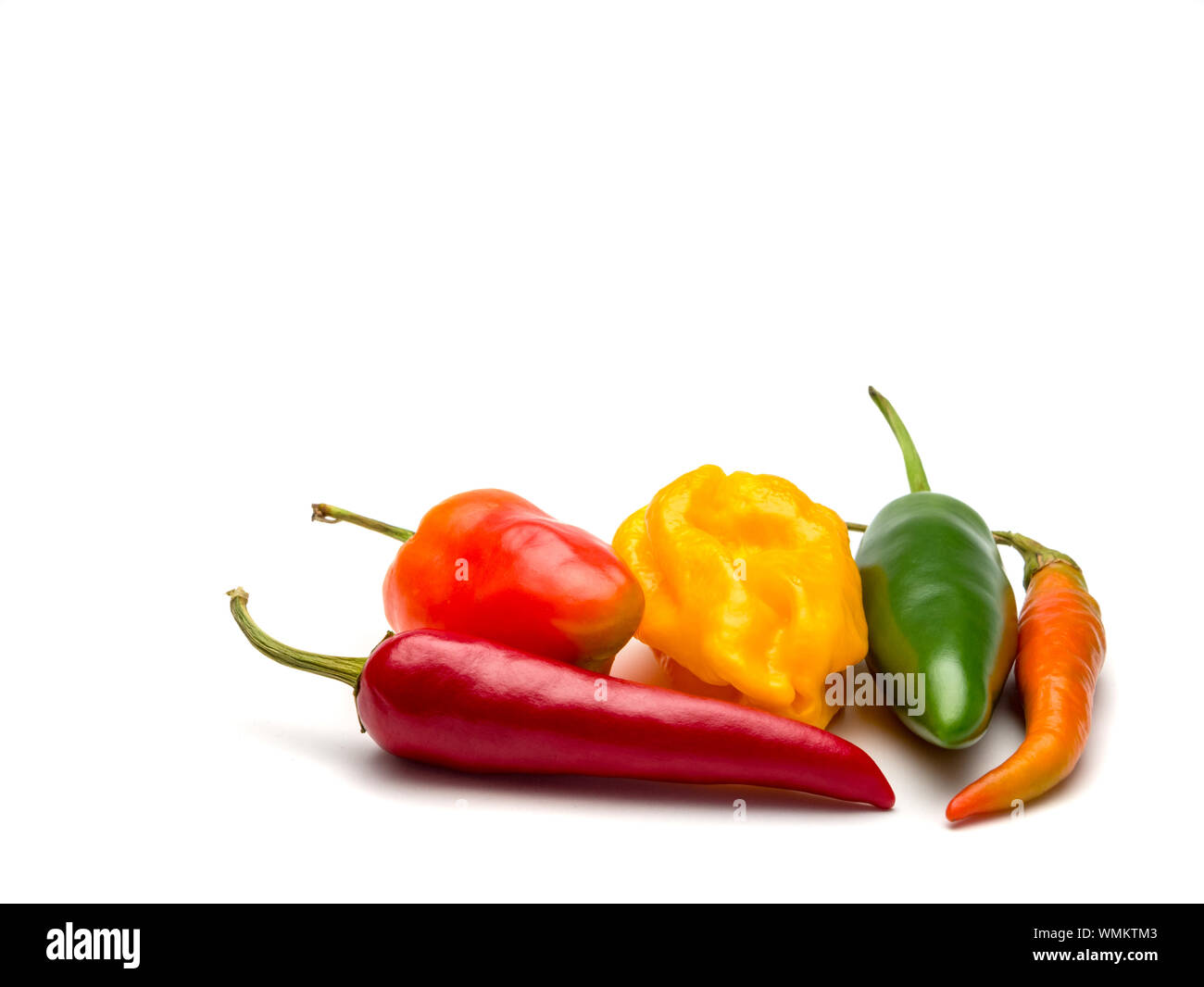 Five peppers of different color and shape isolated on white background ...