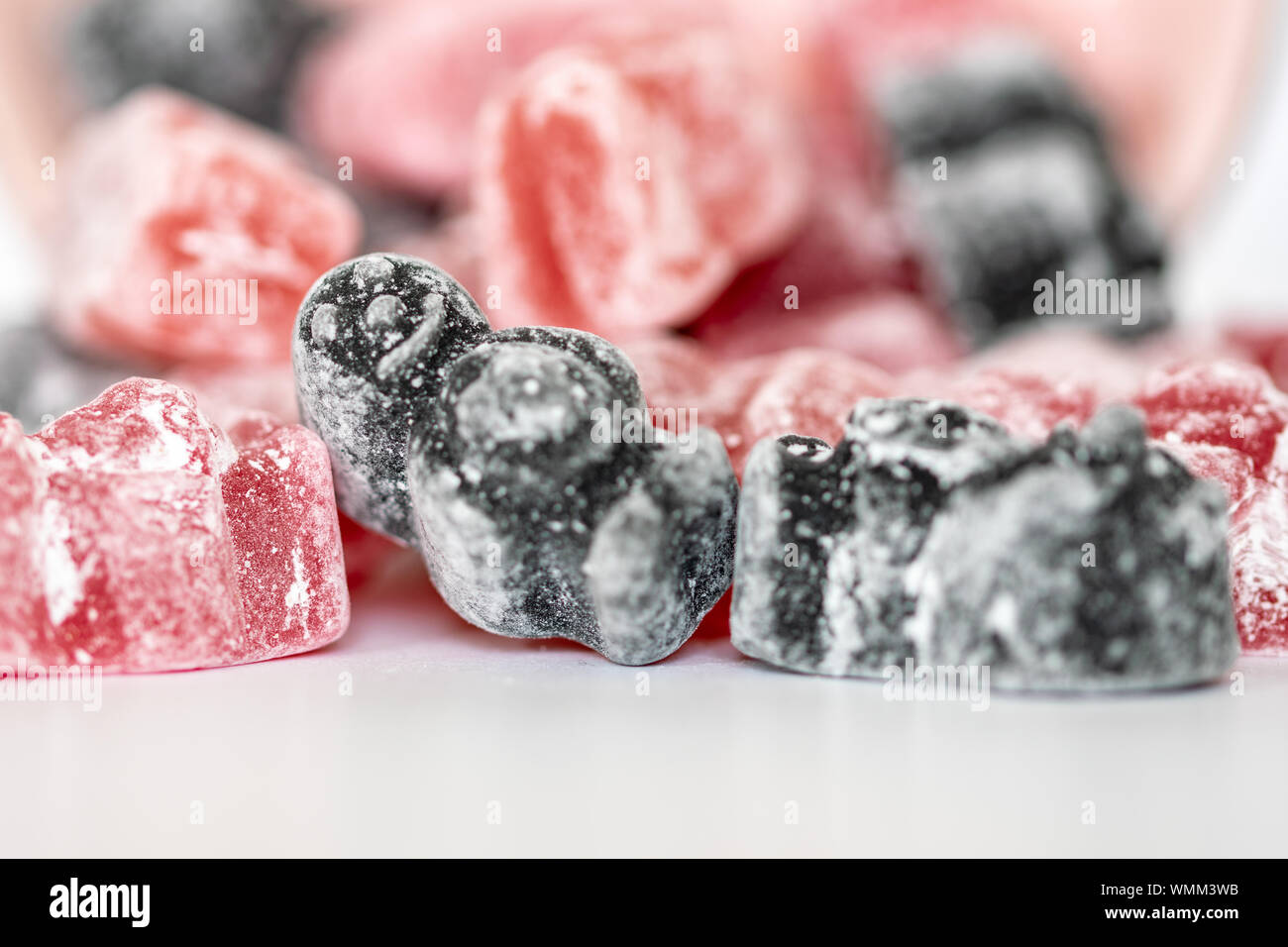A group of pink and black jelly sweets with the face of a dark coloured ...