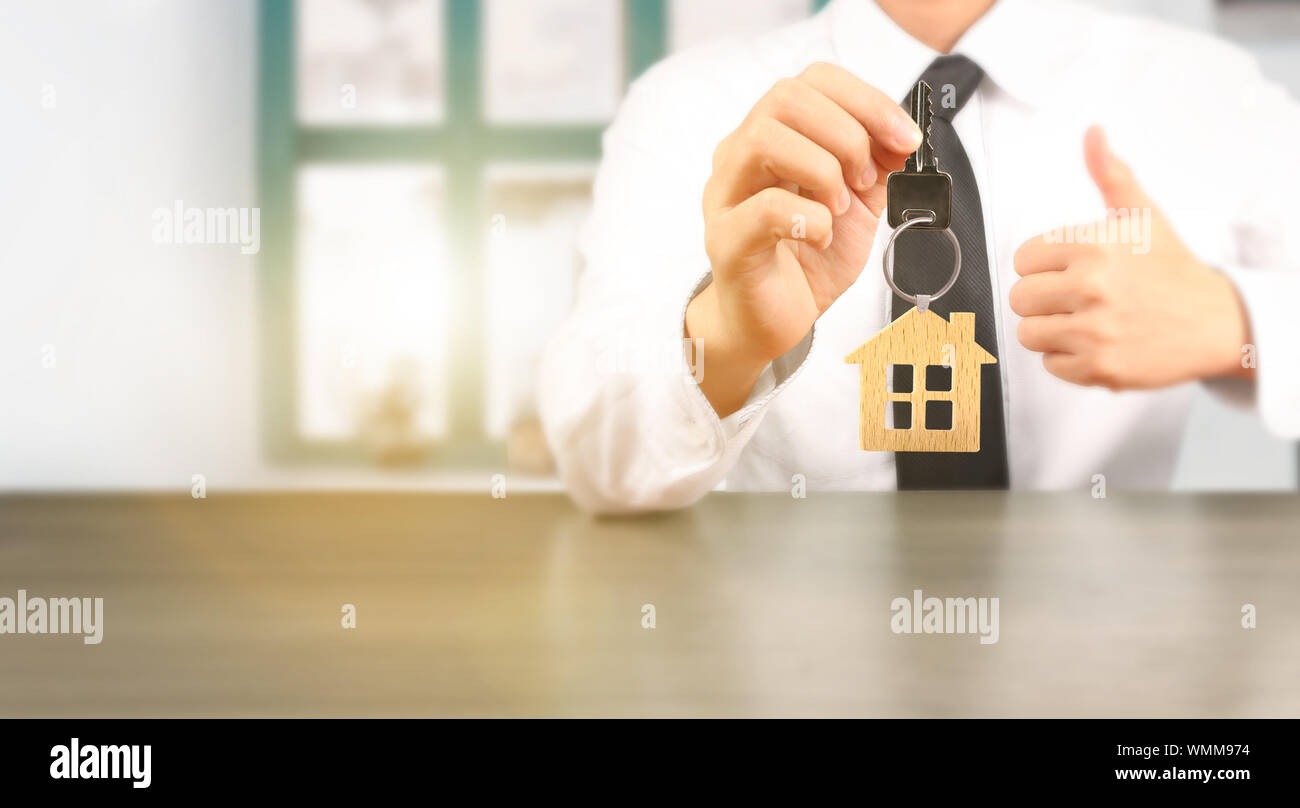 Real estate agent handing over house keys in hand Stock Photo - Alamy