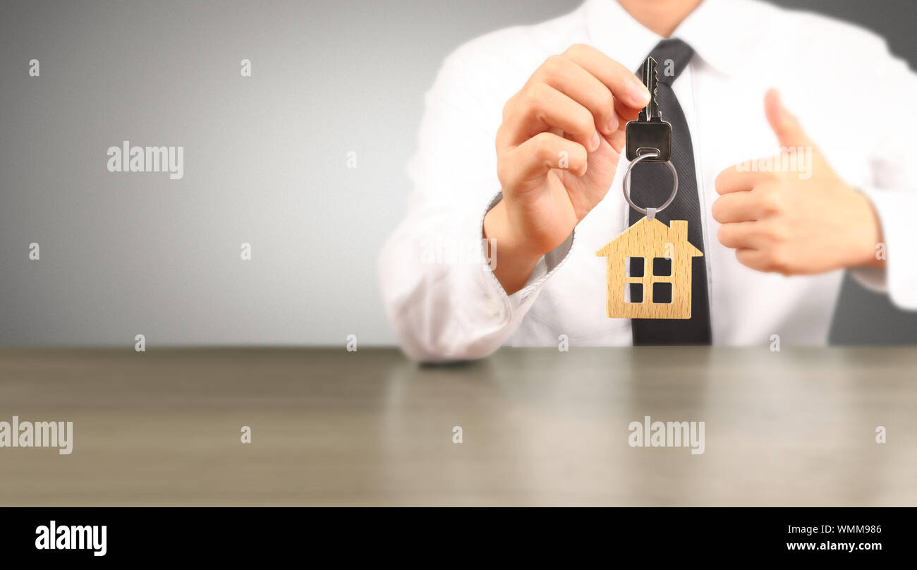 Real estate agent handing over house keys in hand Stock Photo - Alamy