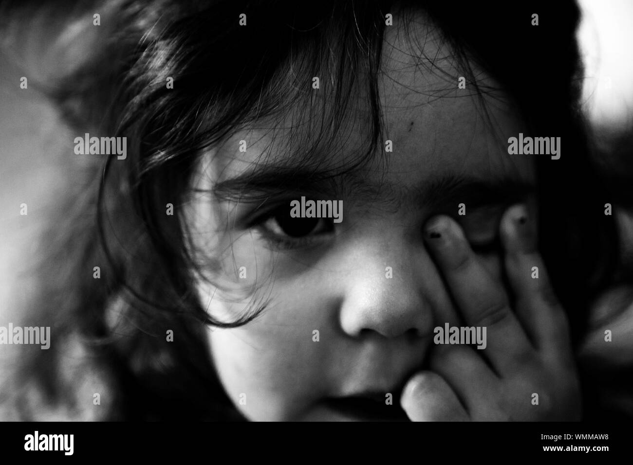 Close-up Portrait Of Cute Girl With Hand On Face Stock Photo - Alamy