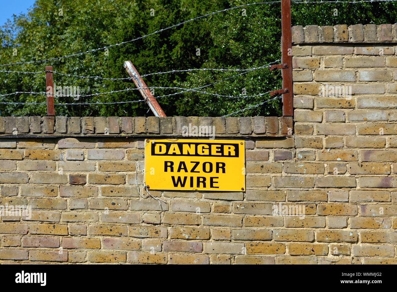 'Danger Razor Wire' warning sign on an exterior brick wall Stock Photo ...