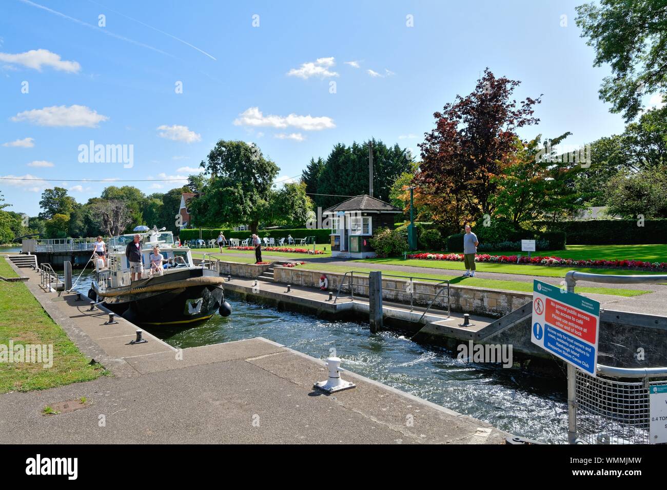 A river cruiser passing through Shepperton lock on a sunny summers day ...