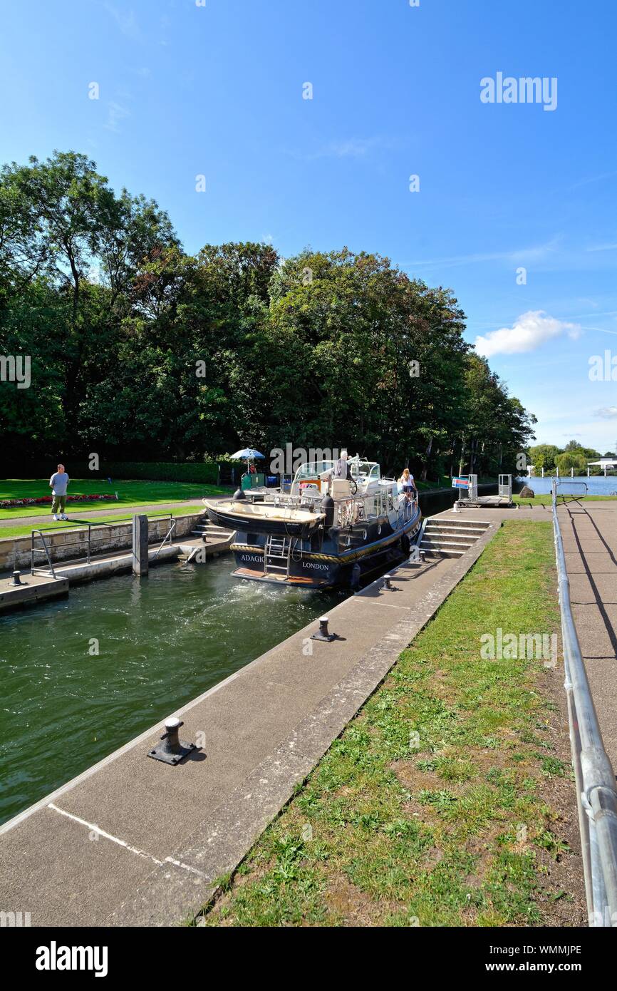 A river cruiser passing through Shepperton lock on a sunny summers day ...