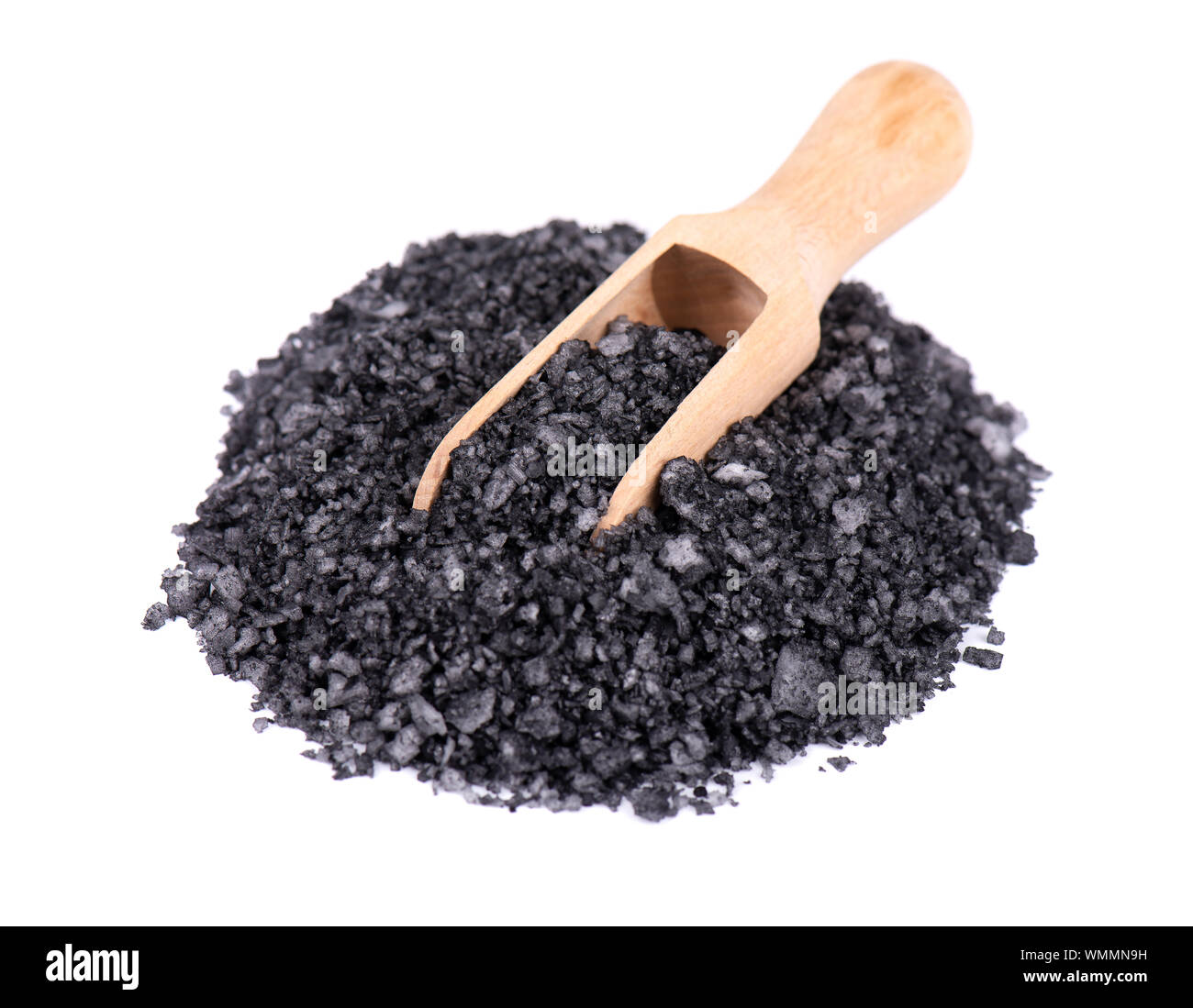 Black sea salt in a wooden spoon, isolated on white background ...