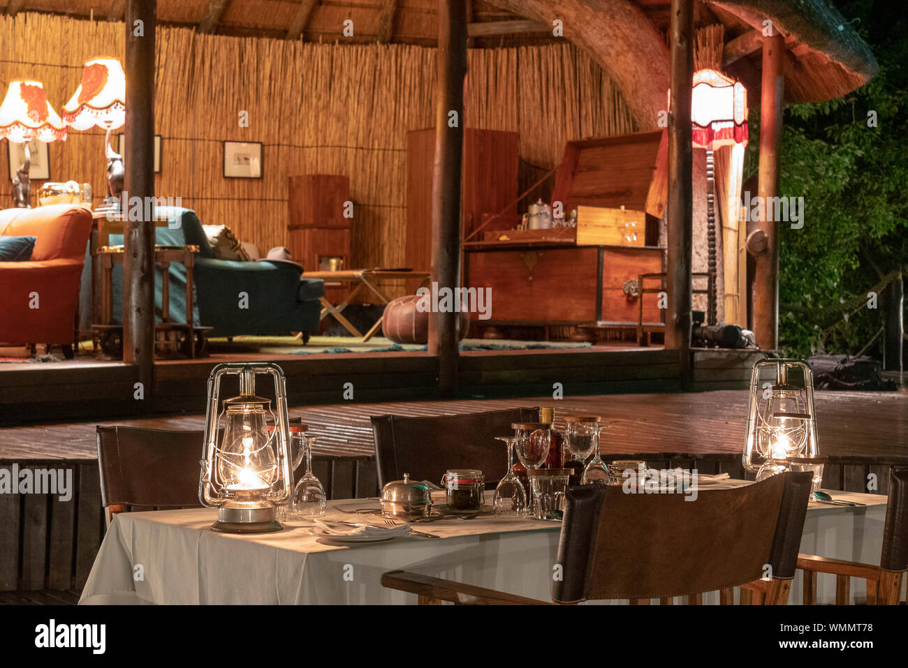 At night, a table set in a luxurious lodge, a lounge in the background ...