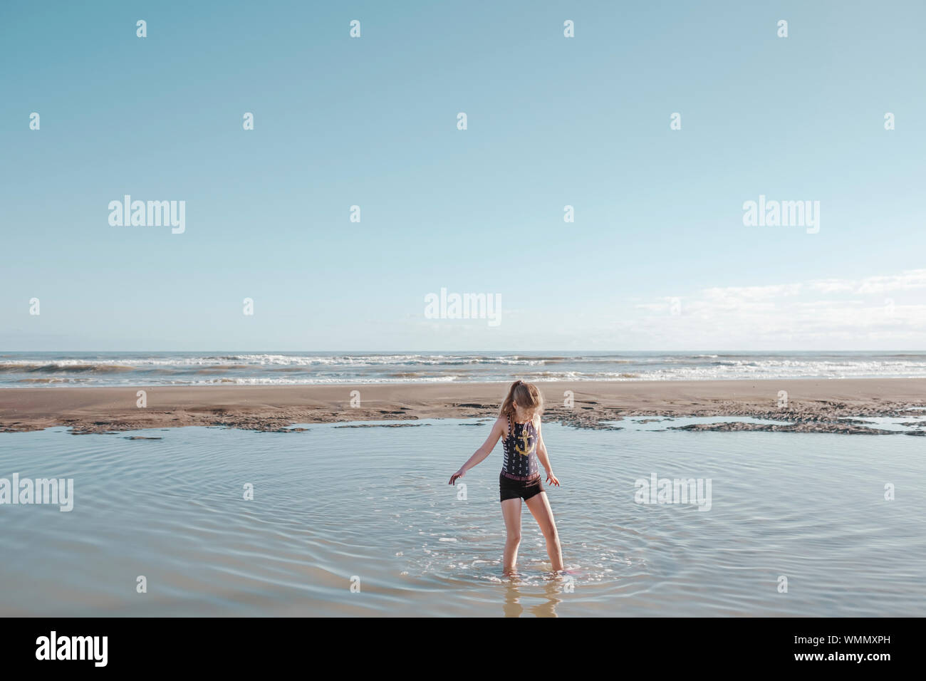 Girl walking through water at the beach Stock Photo - Alamy