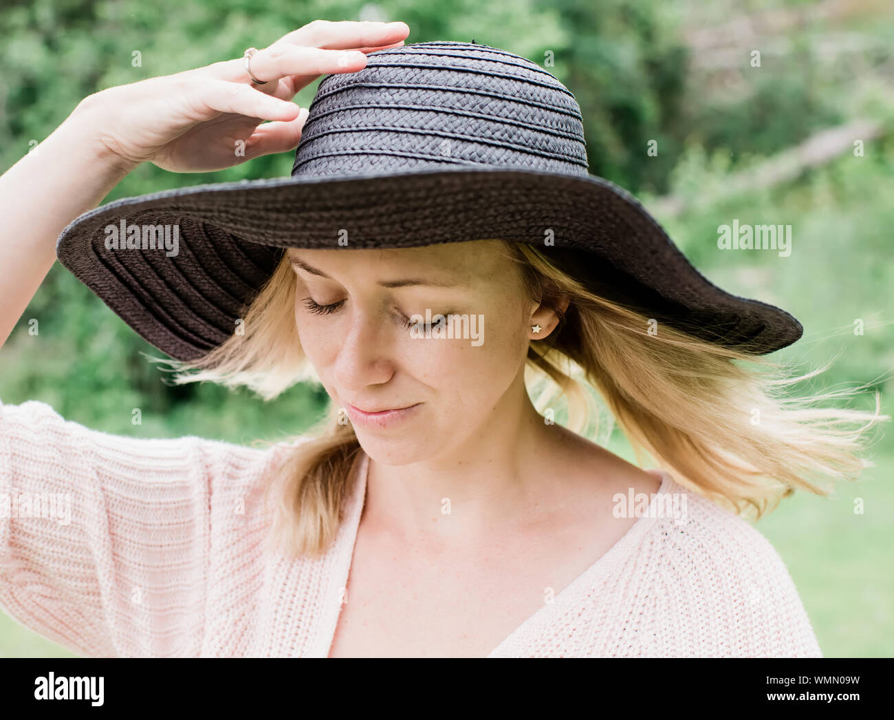 woman standing holding her hat in the wind Stock Photo - Alamy woman standing holding her hat in the wind Stock Photo - Alamy