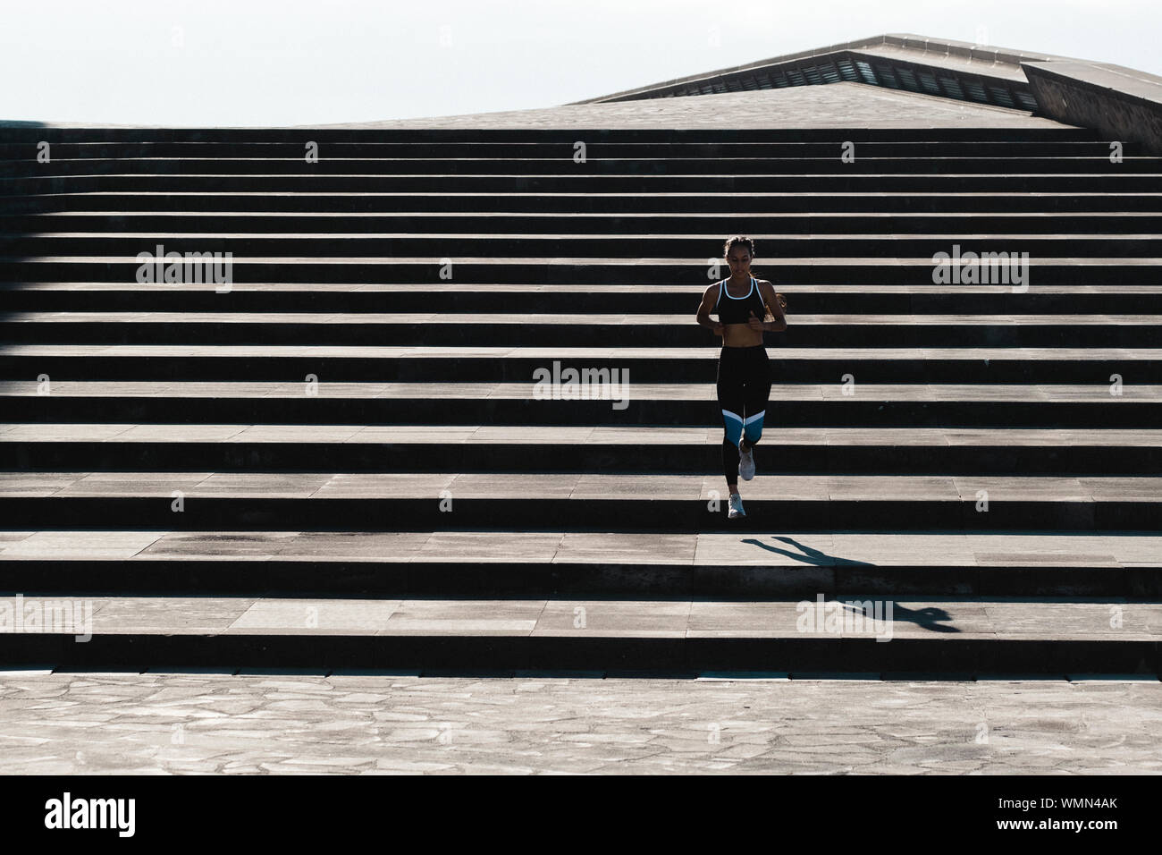 Pulled back of female athlete running on stairs Stock Photo - Alamy