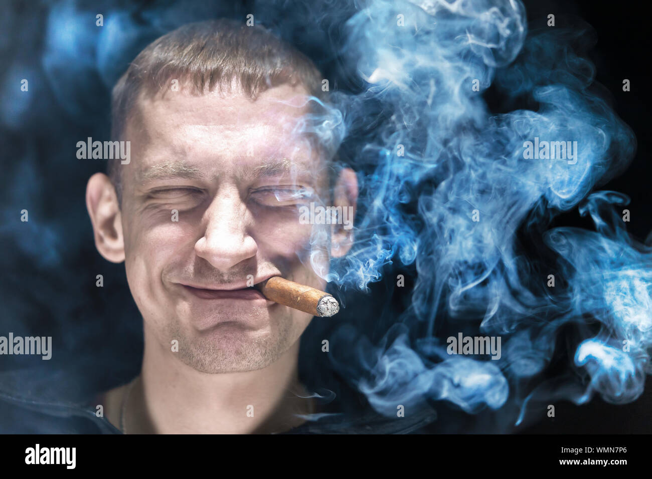 smiles with closed eyes. lots of smoke, portrait of a man close-up face ...