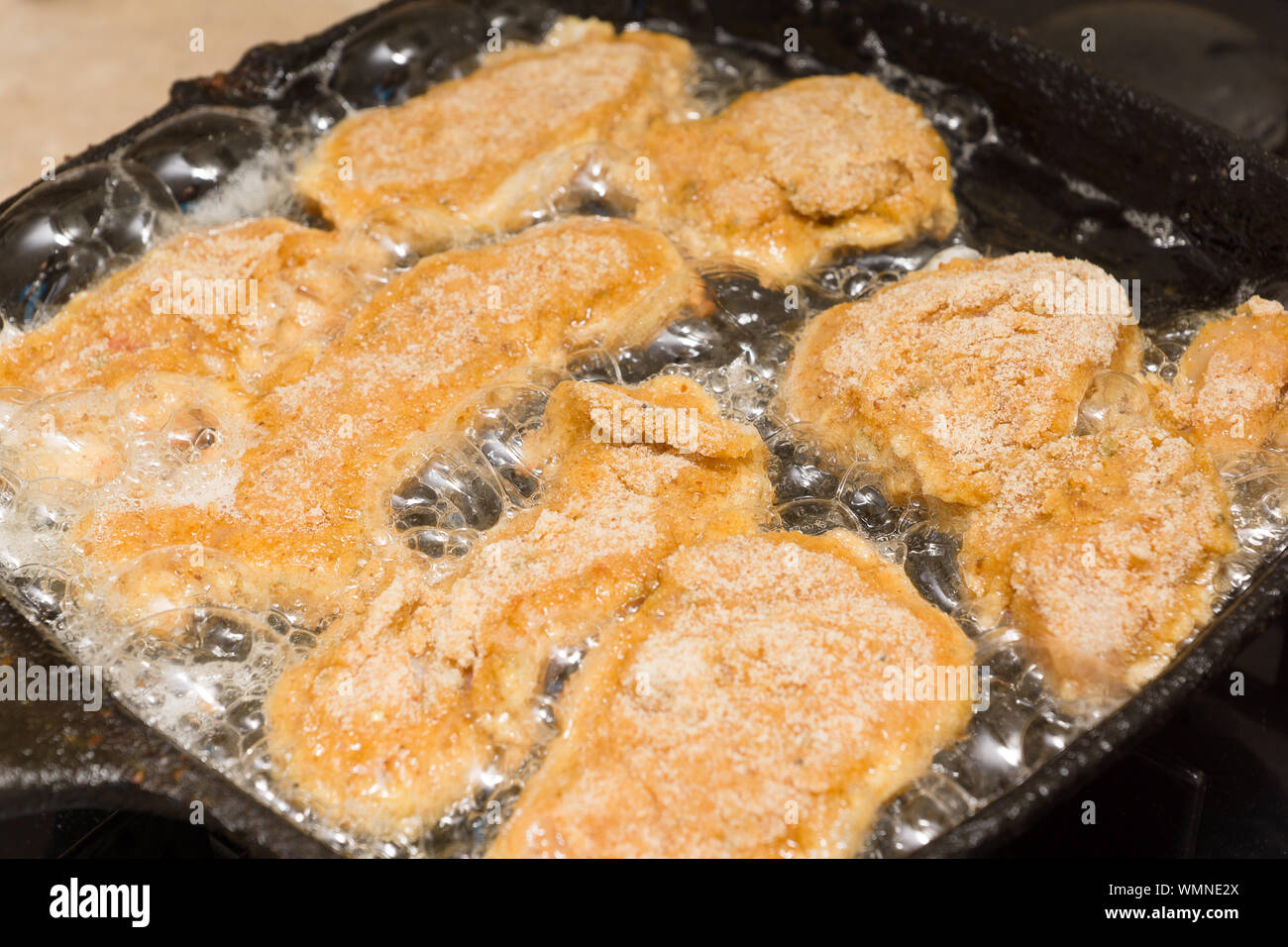 cooking nuggets from fresh chicken meat on a hot cast-iron pan Stock ...