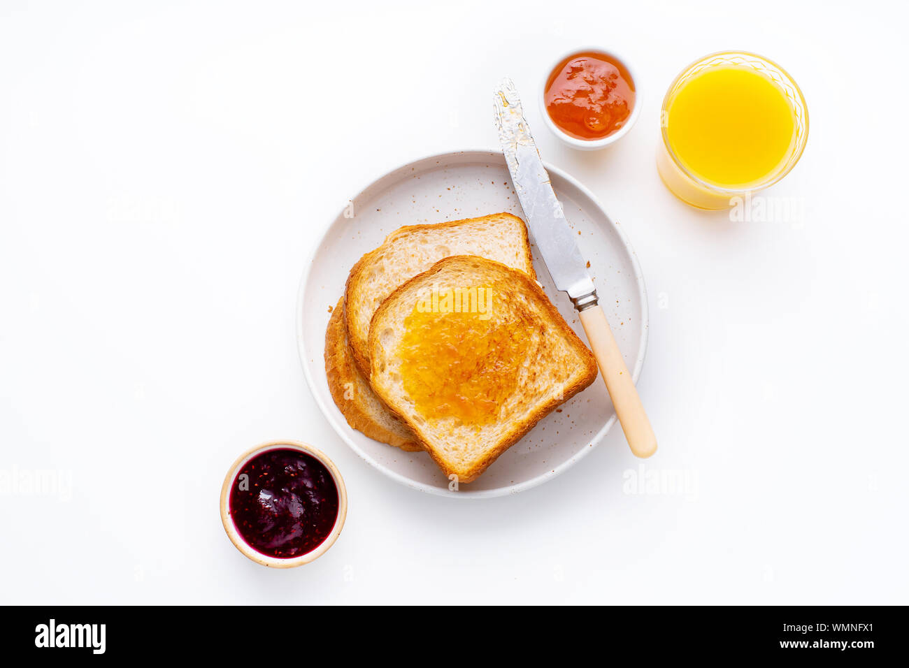 Morning toasts with butter and confiture on white table served with ...