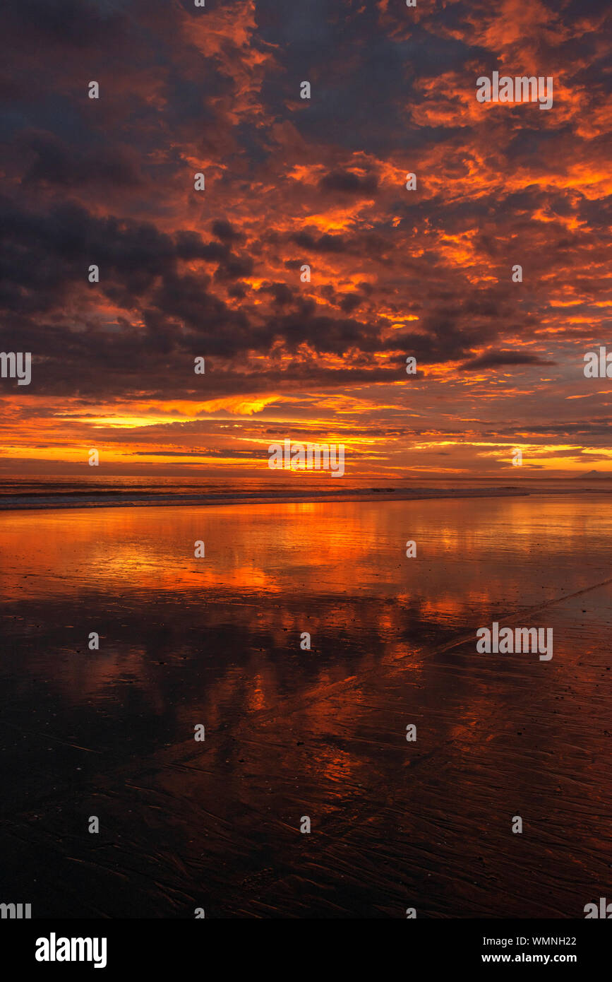 A portrait view of a brilliant sunset plus its reflection in a glass ...