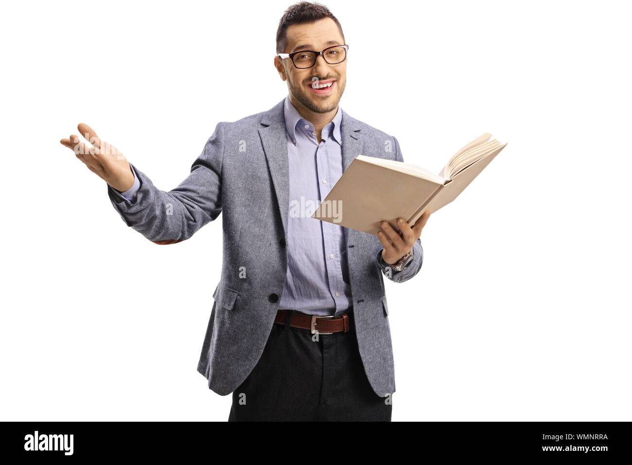 Young man standing and holding an open book and gesturing with hand ...