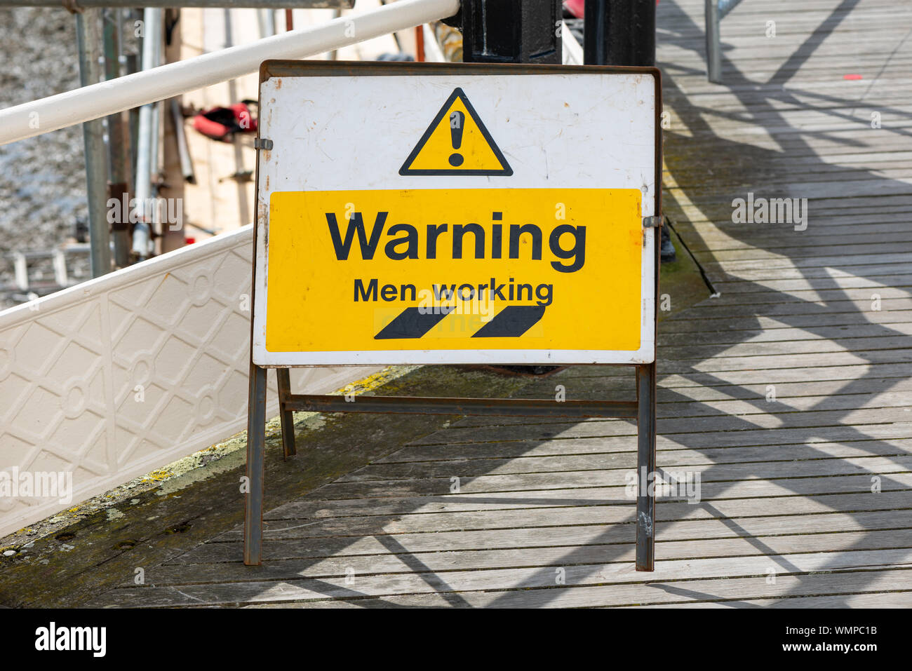 A yellow warning men working sign Stock Photo - Alamy