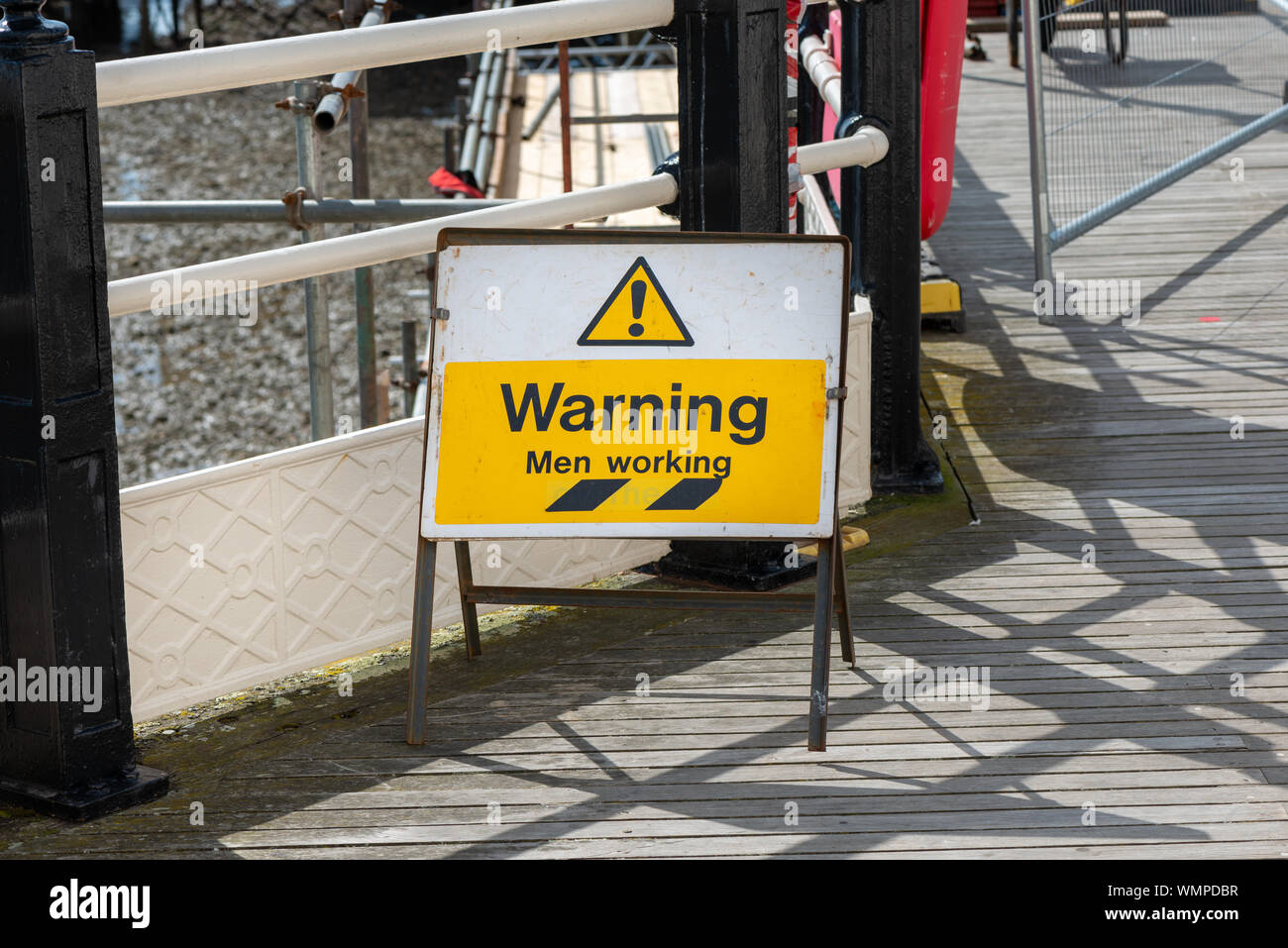 A yellow warning men working sign Stock Photo - Alamy