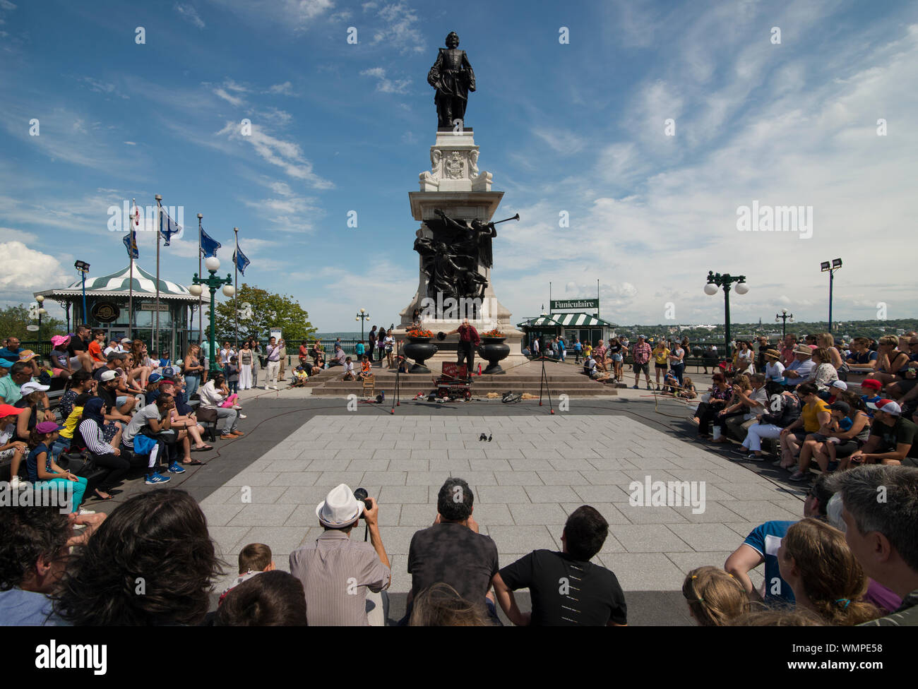 Busker, street performer, plays to a large crowd on a summer afternoon ...