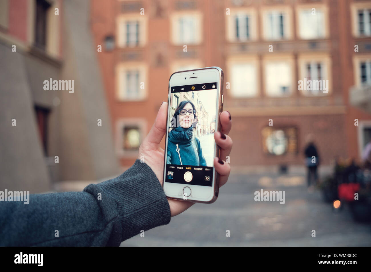 Back close up view of female person holding cellphone with and make ...