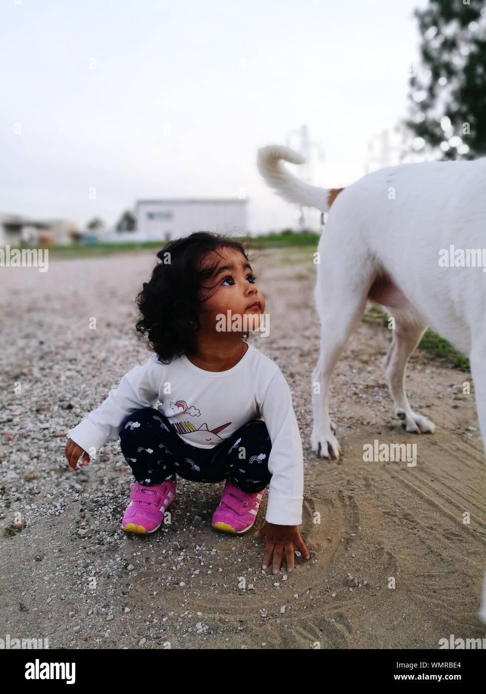 Full Length Of Cute Girl Crouching Outdoors Stock Photo - Alamy