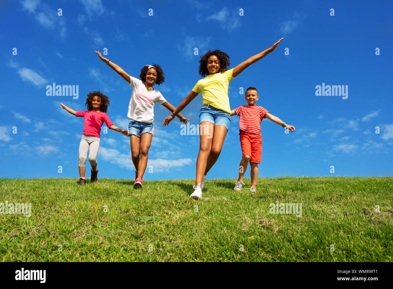 Many kids with hands in flying pose run down hill Stock Photo - Alamy