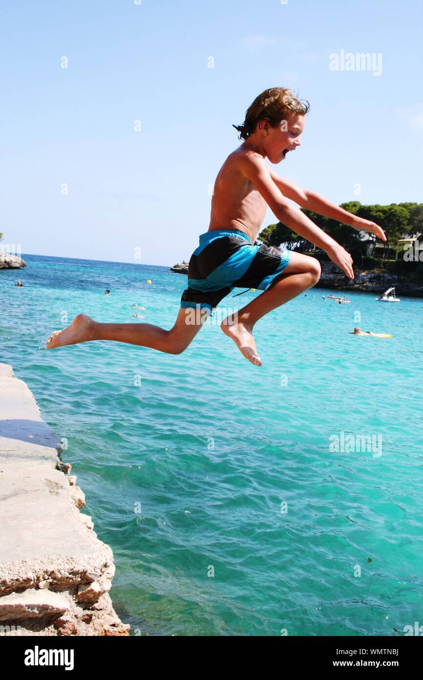 Boy jumping into the sea hi-res stock photography and images - Alamy