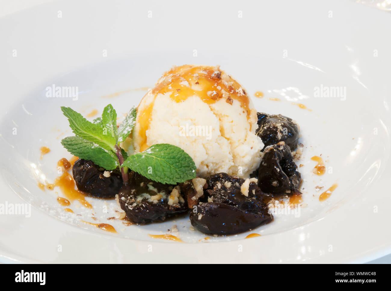 Plums marinated in rum with vanilla ice cream and caramel sauce Stock ...