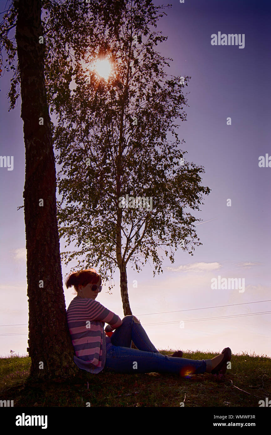 Woman Sitting Against Tree Trunk High Resolution Stock Photography and ...