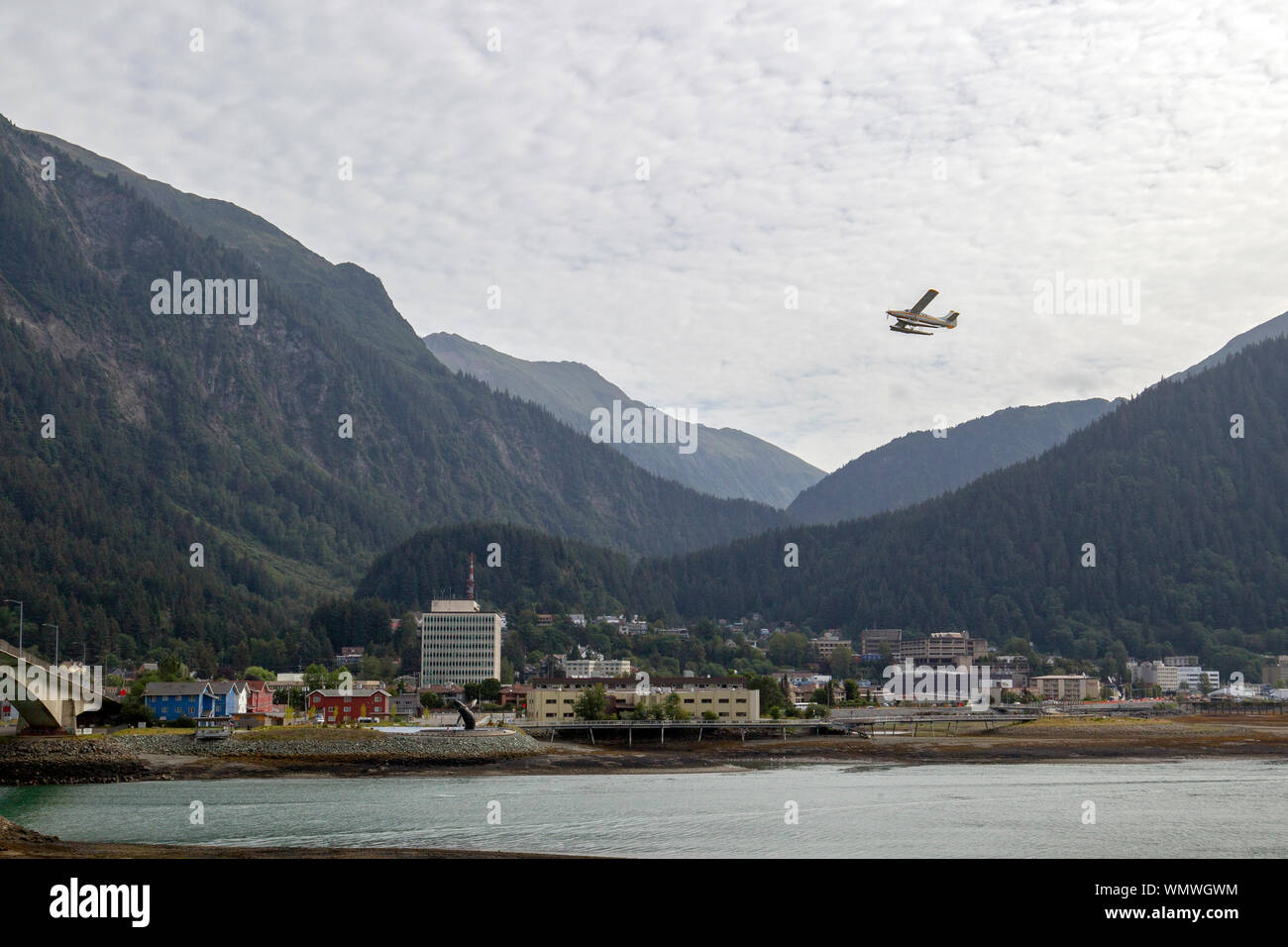 Downtown Juneau Alaska from Douglas Island with a sea plane taking off ...