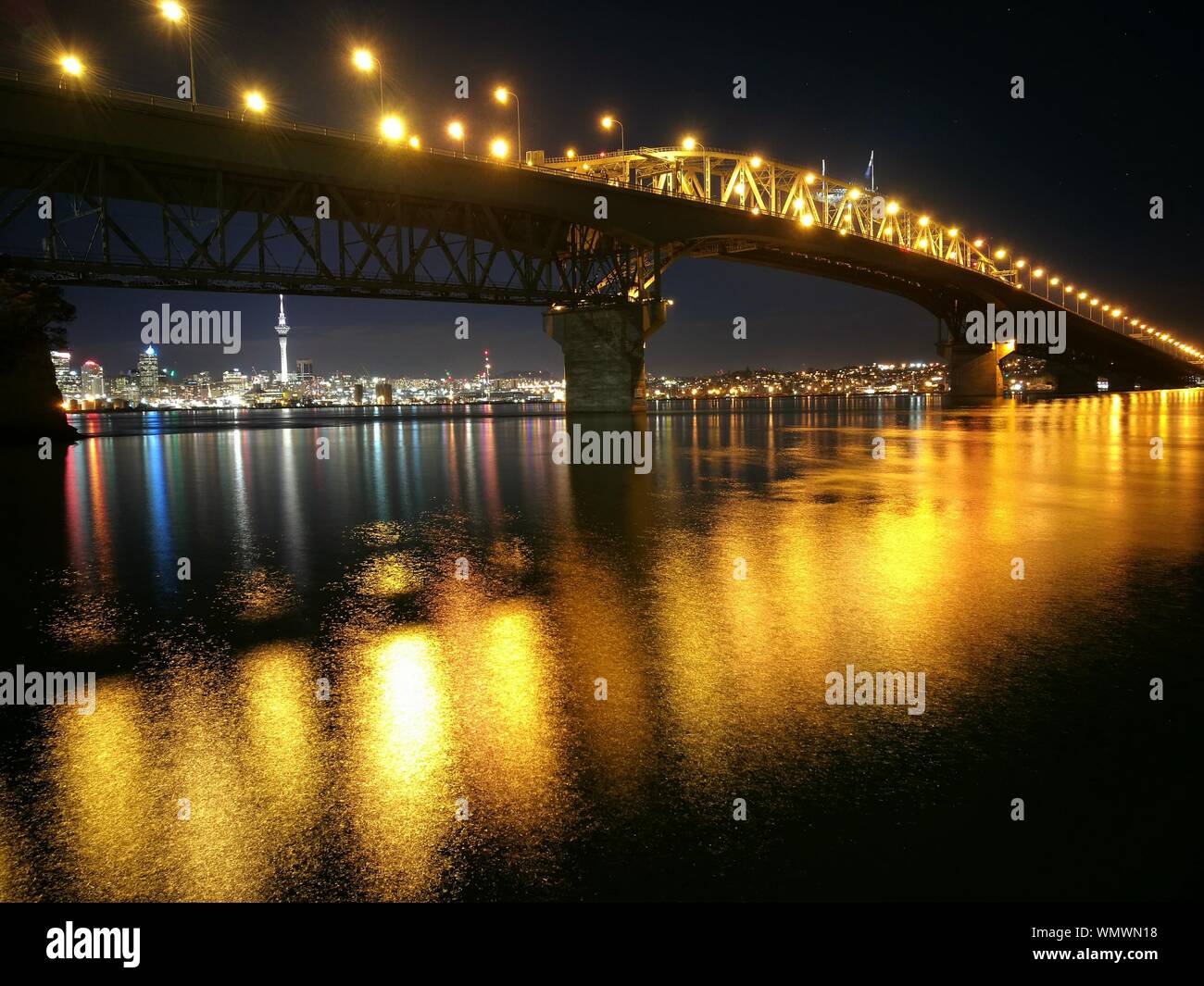 Illuminated Bridge Over River In City At Night Stock Photo - Alamy
