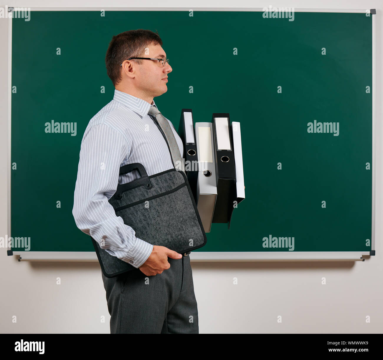 Portrait of a men dressed in business suit with folders, documents and ...