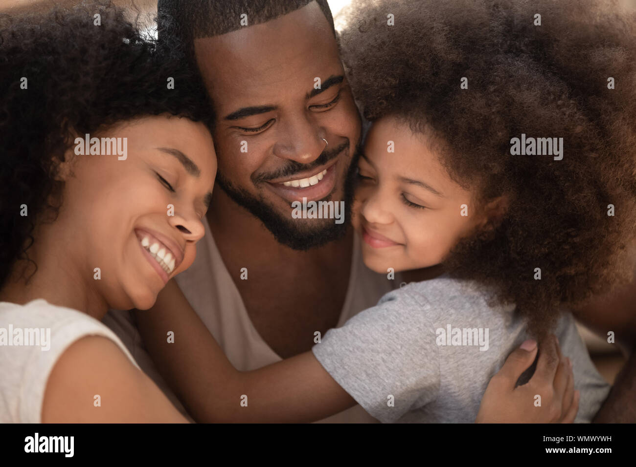 Close up happy african american family embracing Stock Photo - Alamy