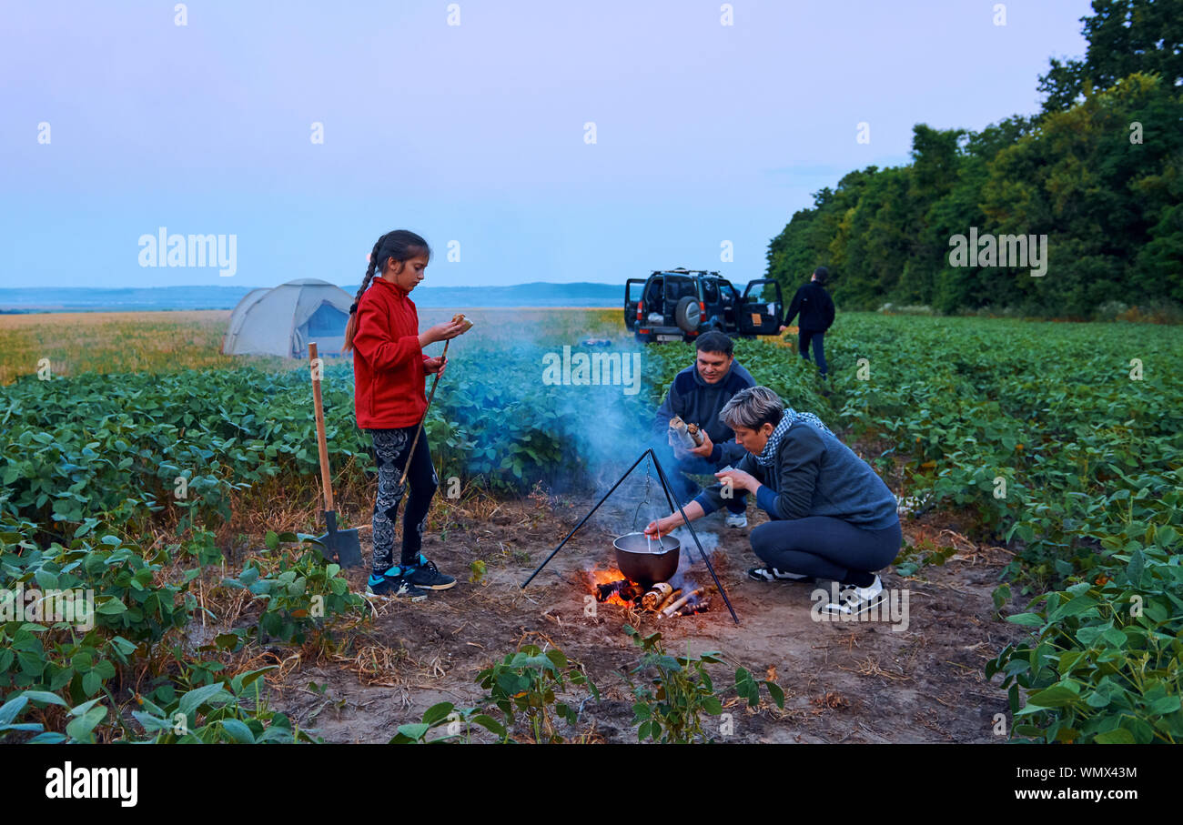 Family traveling and camping, twilight, cooking on the fire. Beautiful ...
