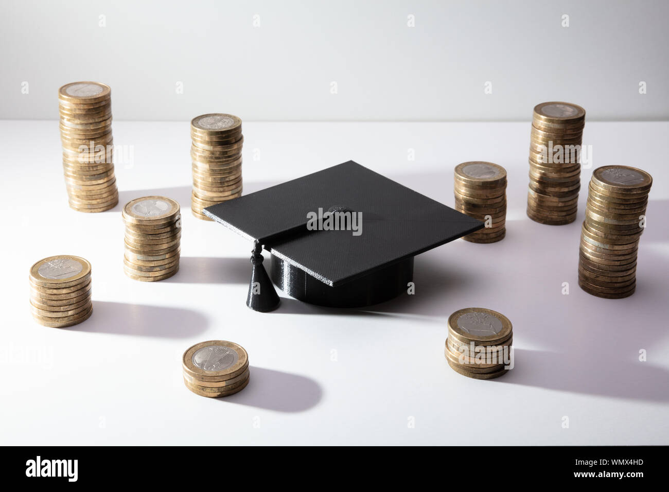 Black Graduation Hat With Golden Stacked Of Coins On White Background ...