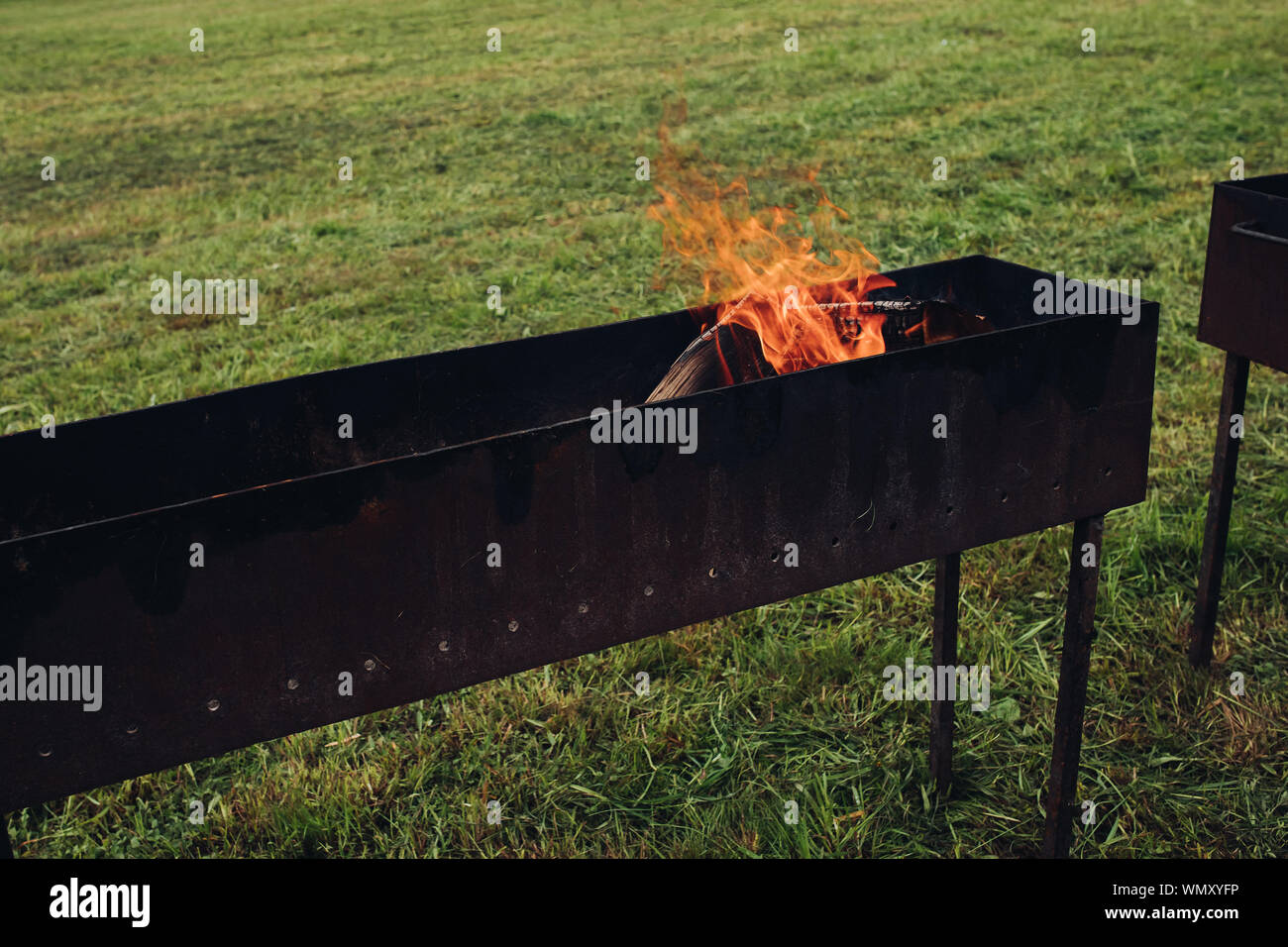Side view of brazier with flaming fire and firewood Stock Photo - Alamy