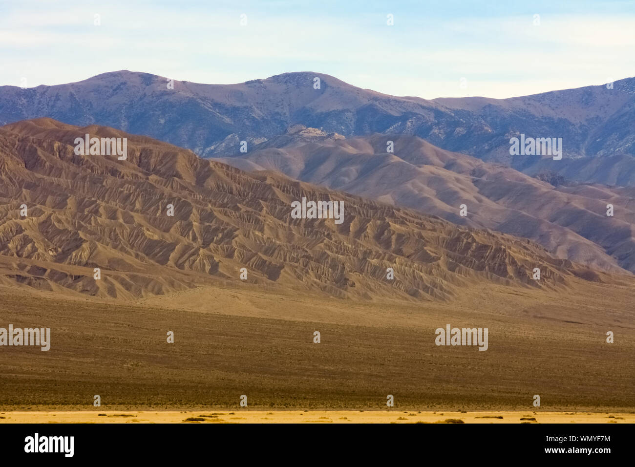 Colour landscape photograph of heavily scarred dry hills in distance ...