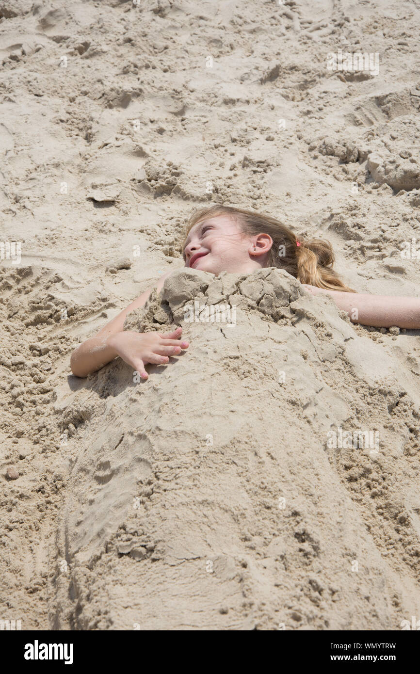 Girl buried in sand hi-res stock photography and images - Alamy