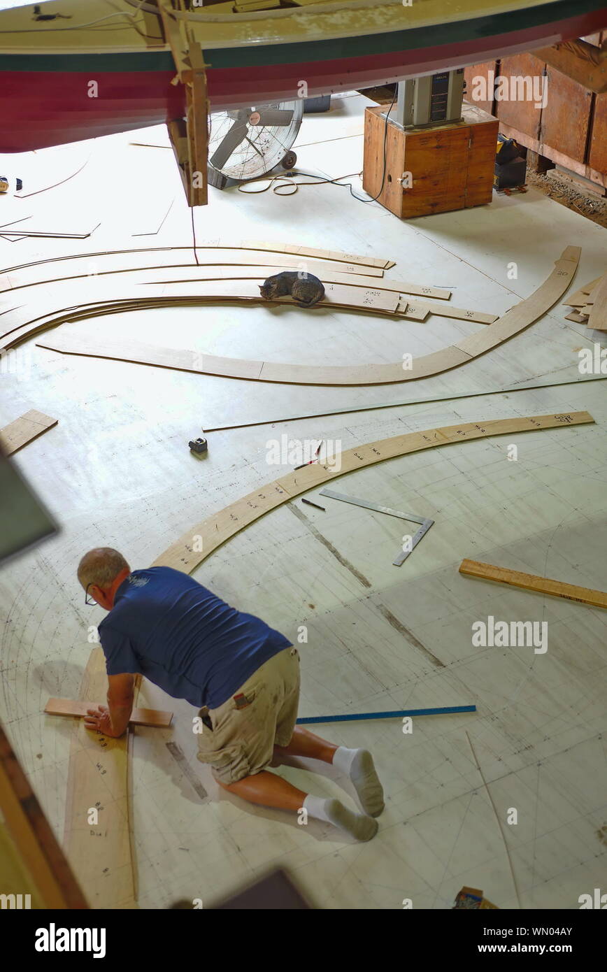 Shipwright traces hull rib patterns for a boat restoration project ...
