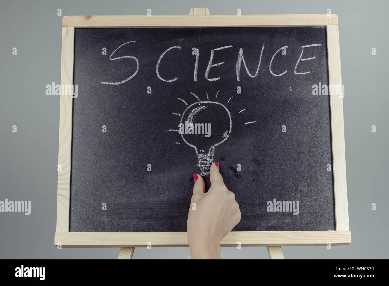 A teacher writing science, drawing chemistry elements on dark ...