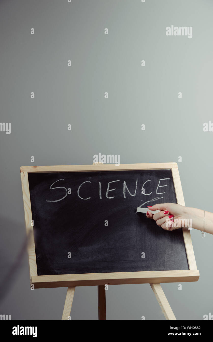 A teacher writing science, drawing chemistry elements on dark ...