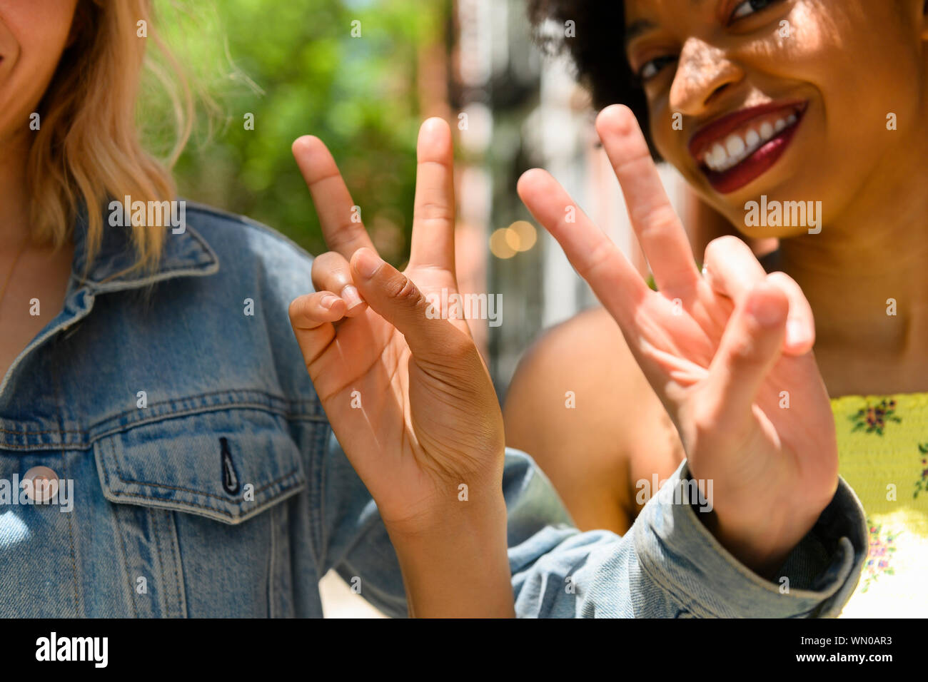 Friends doing peace signs Stock Photo - Alamy