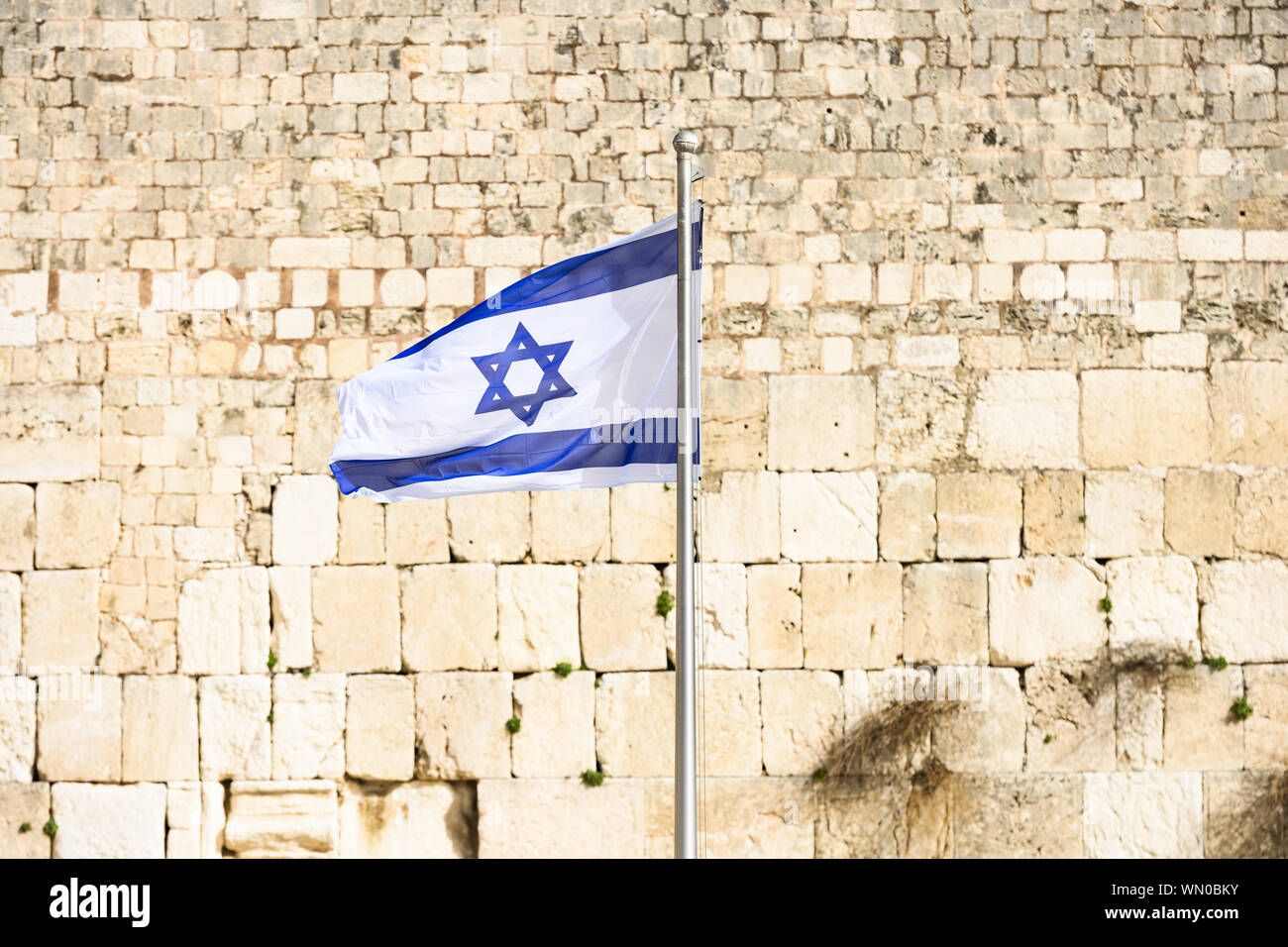 Close-up view of the Israeli Flag waving in front of the Western Wall ...