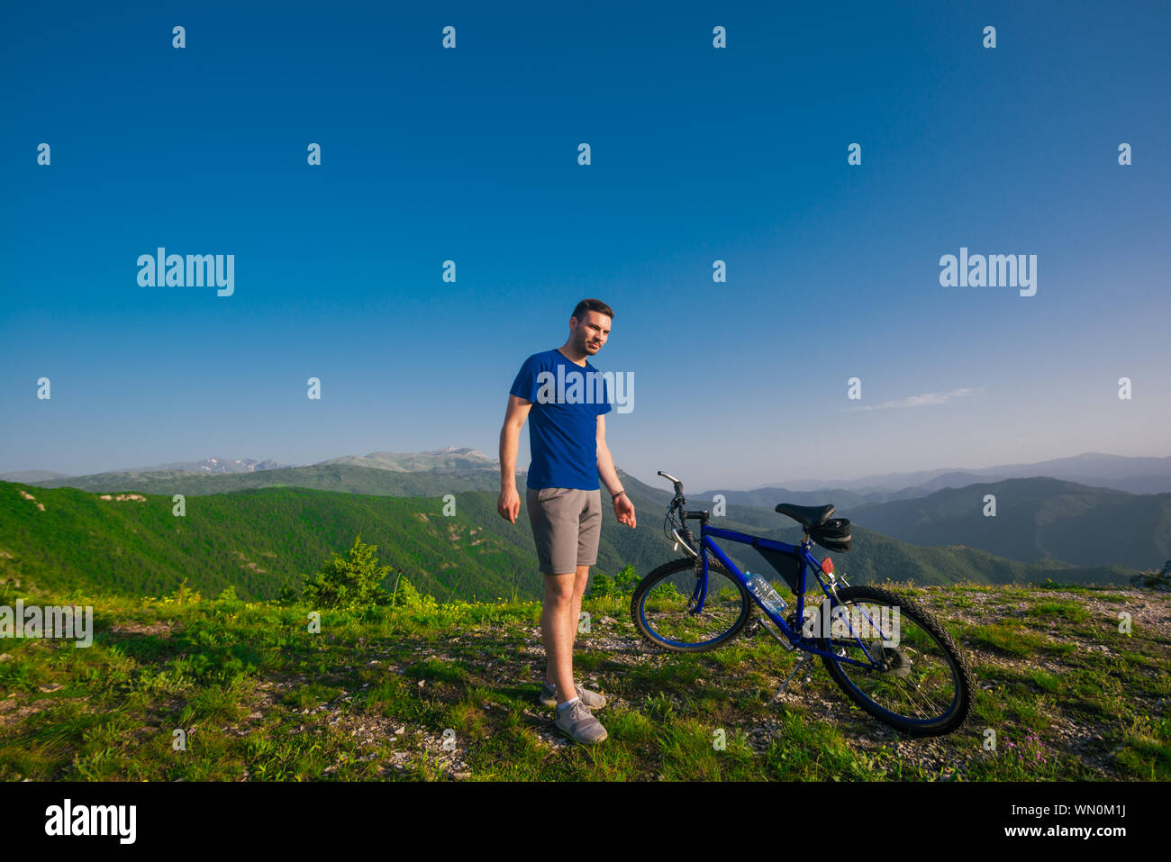 Adventurous Cyclist riding his mountain bike at the edge of a cliff, on ...